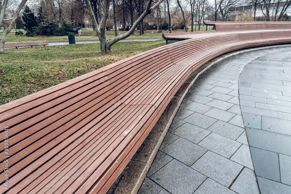 Modern long wooden bench in the park. Design of urban public space. The ...
