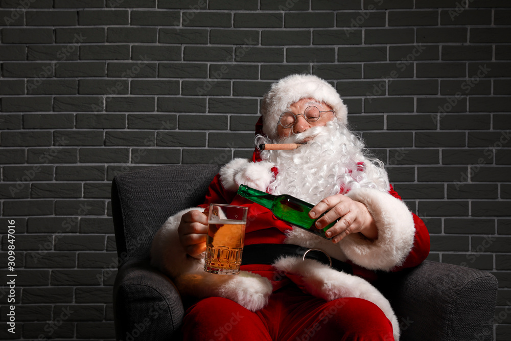 Funny drunk Santa Claus sitting in armchair against brick background ...