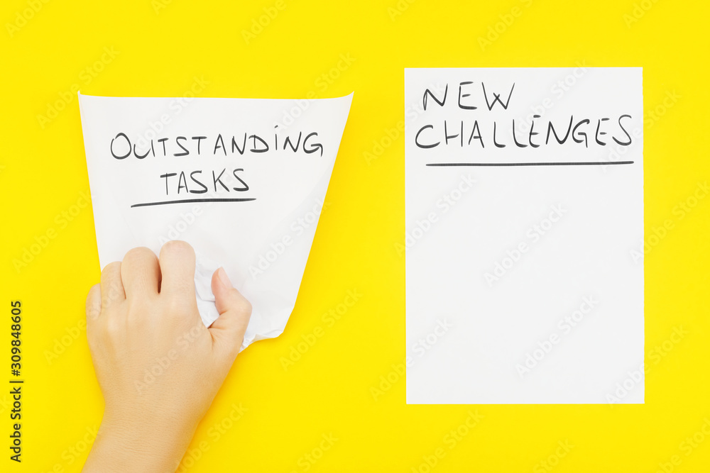 Hand wrinkles a piece of paper with phrase: outstanding tasks, and ...