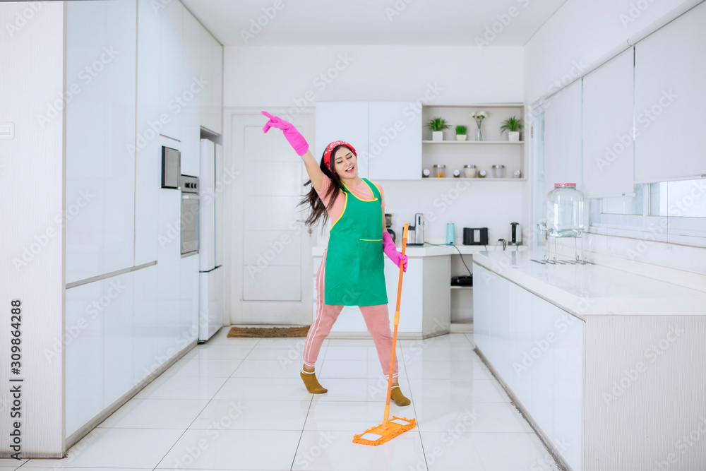Beautiful woman dancing around while mopping Stock Photo | Adobe Stock