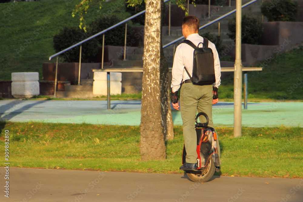 Foto de A man without helmet rides on an electric monowheel ride on an ...