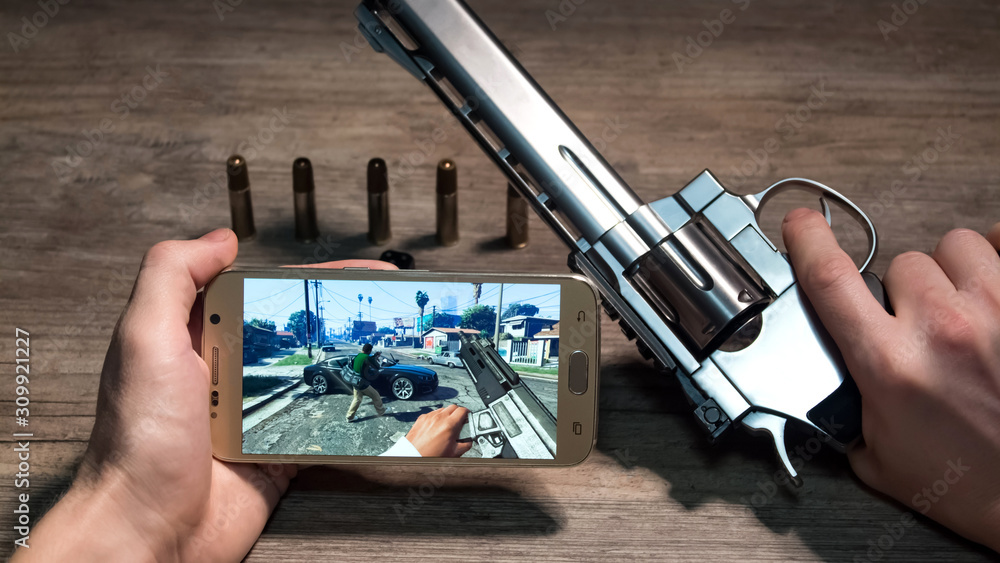 Passion for modern phone and computer games. Hands holding a phone with ...