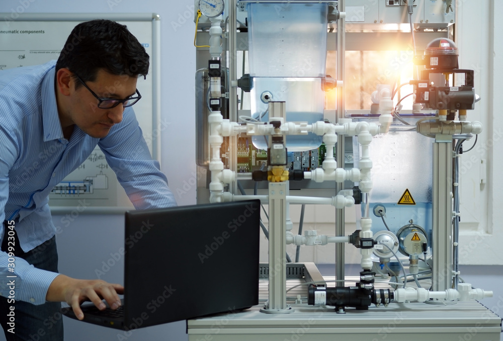 Close up of PLC programming Engineer's laptop and analog process ...