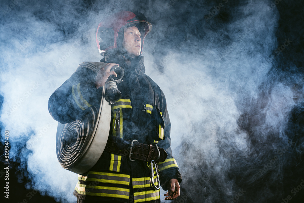 young fire fighter holding rope in hands ready to save and protect from ...