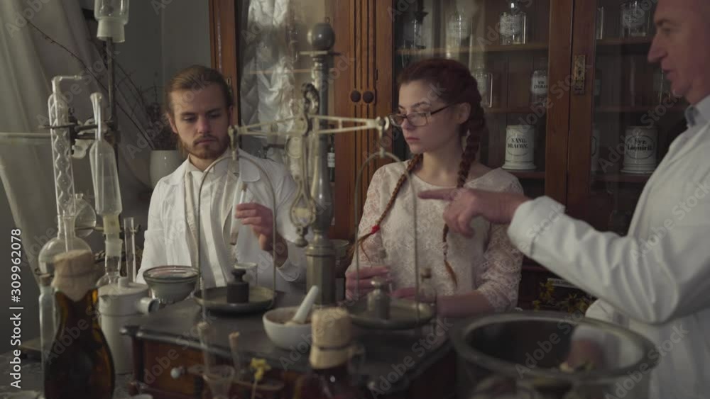 Portrait of three Caucasian apothecaries talking. People standing in ...