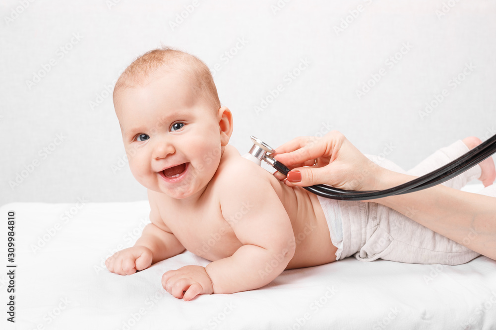 Baby medical exam - doctor checking heart beat and lungs with ...