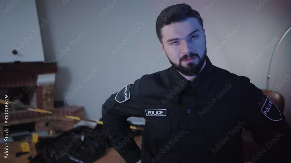 Portrait of tired Caucasian police officer rubbing eyes and looking at ...
