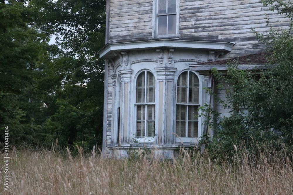 Old abandoned historic farmhouse with broken windows and peeling paint ...
