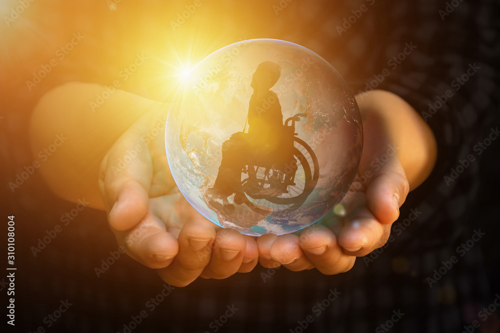 Disabled person on wheelchair in earth holding in human hands towards ...