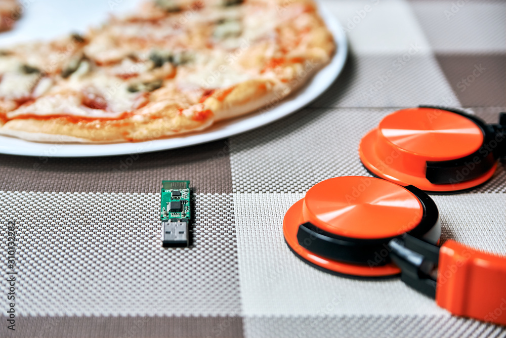 on the table are a usb flash drive headphones and pizza Stock Photo ...