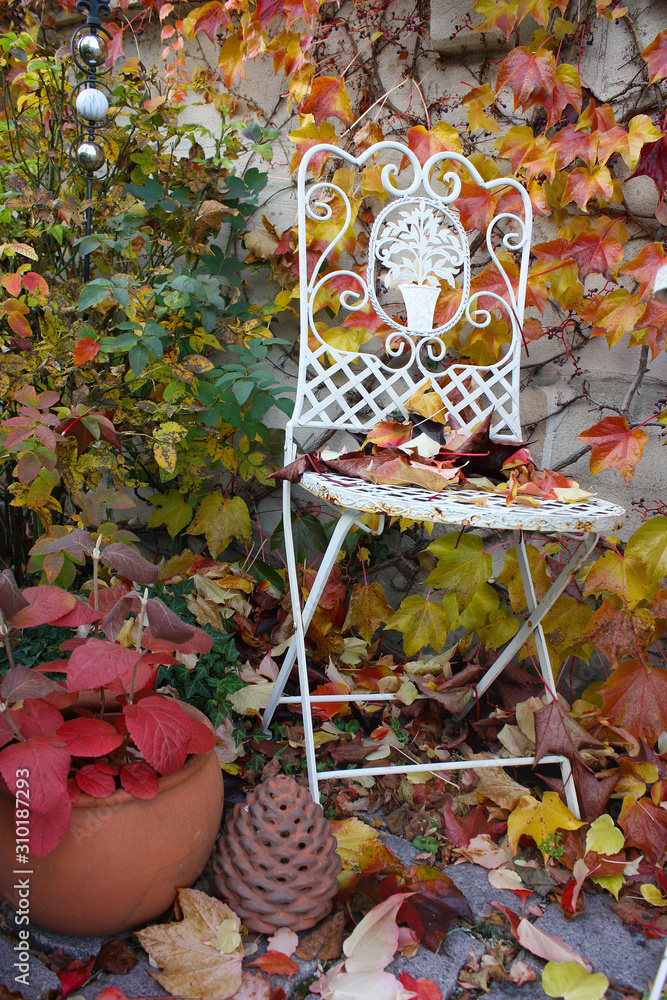 Leicht maroder Eisenstuhl mit shabby chic steht umrahmt von buntem ...