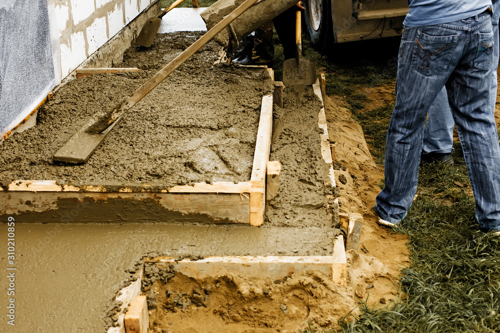 Workmen team in the process of forming foundation blind area. Concrete ...