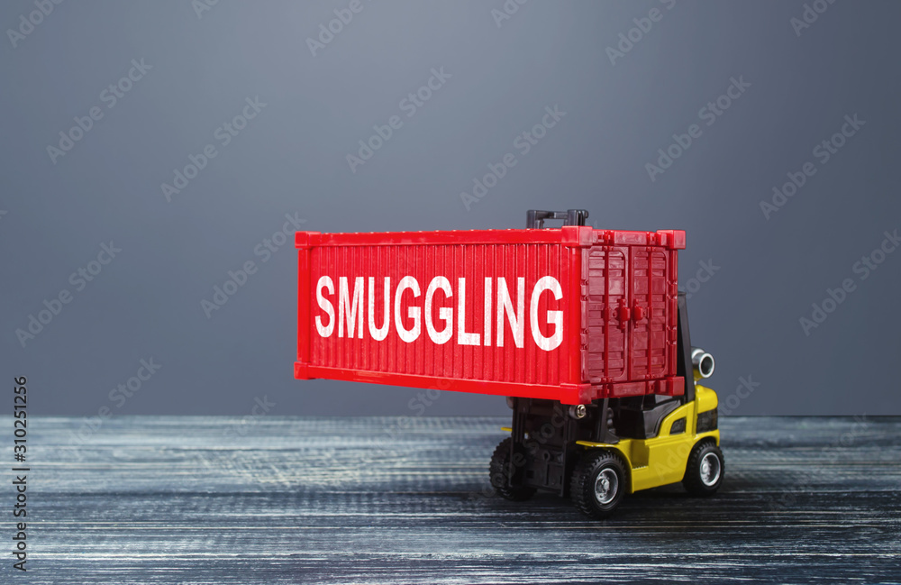 A forklift truck carries a red container labeled smuggling ...