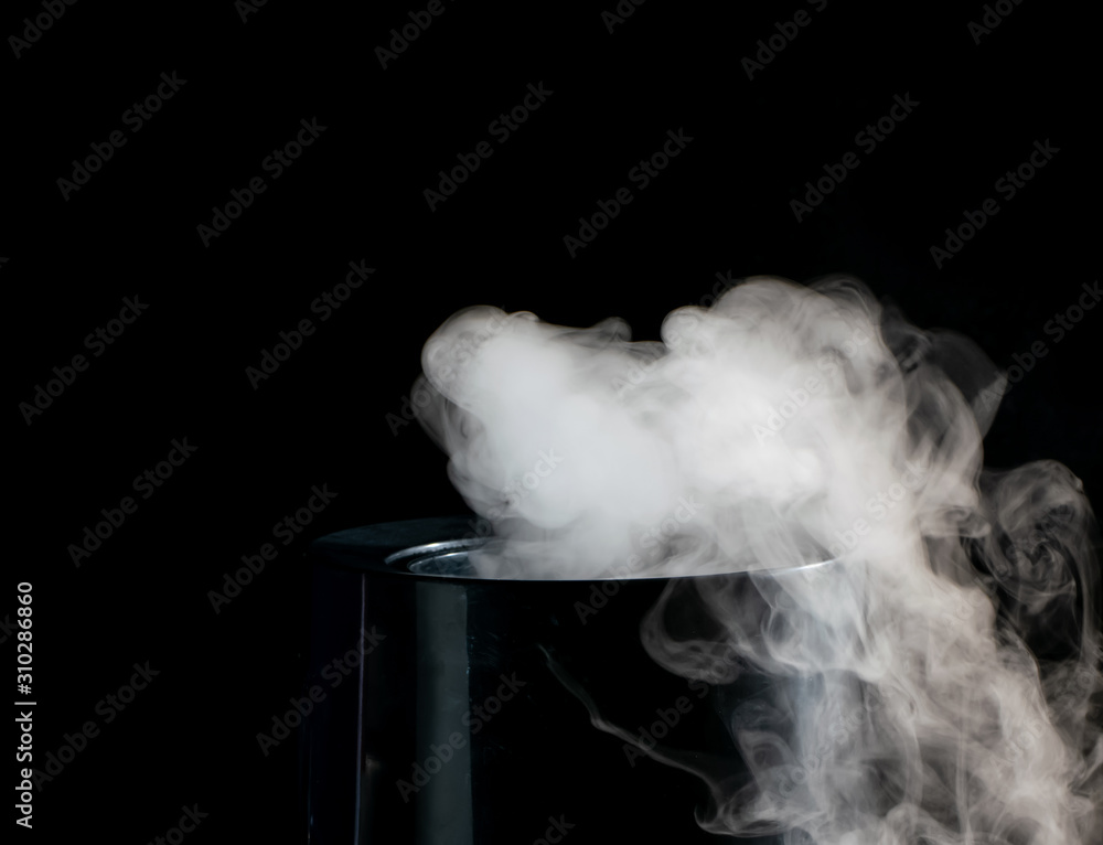 Puffs of white smoke randomly rising rise from the chimney partially ...