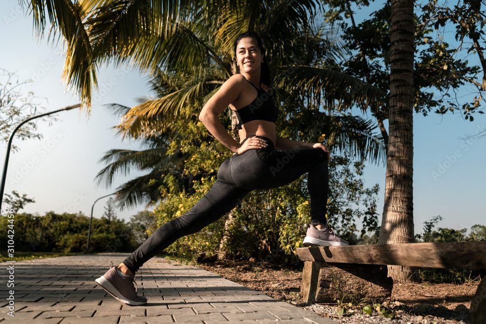 Fit girl doing standing hamstring stretch after a run in nature Stock ...