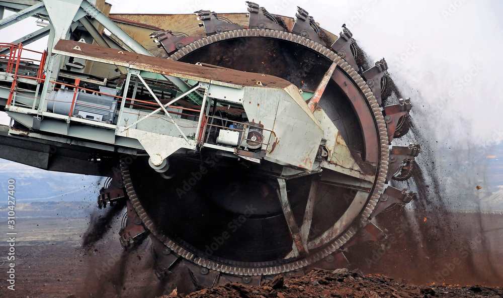 A huge bucket-wheel excavator digging coal on the open-pit mine. Stock ...
