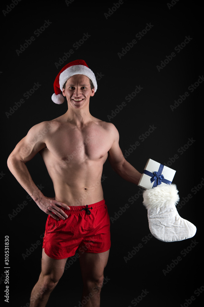 Stocking stuffers. Muscular man wear santa claus hat. Bodybuilder on ...