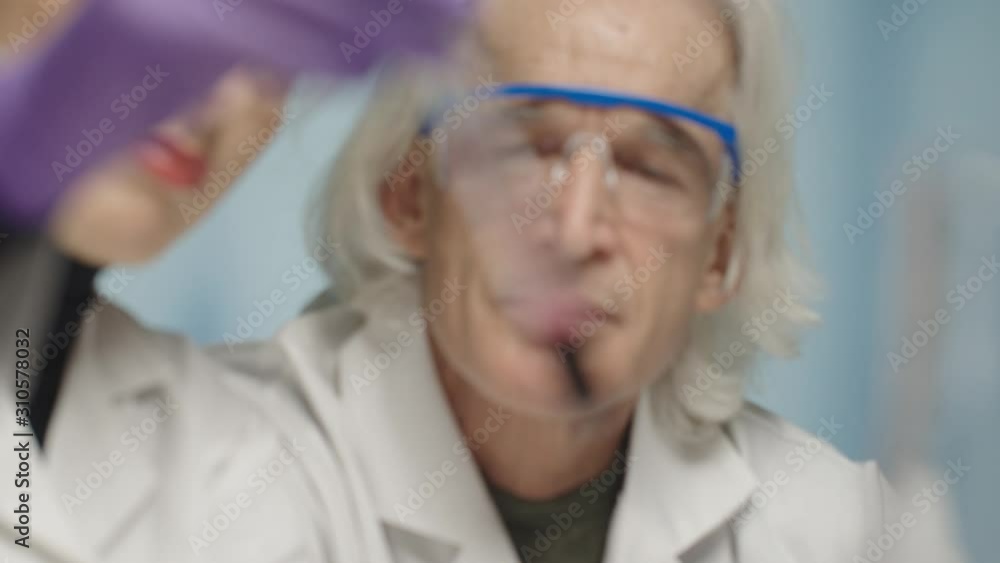 two chemists analysing analysing blood sample in a test tube in the ...