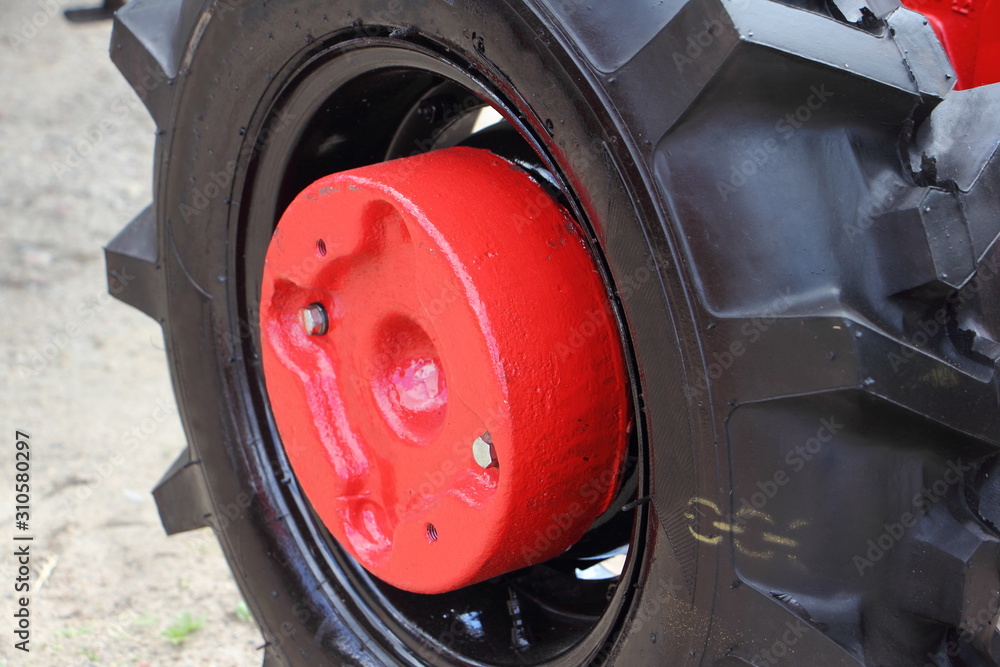 New Red wheel weight on walk-behind tractor wheel disc close up ...