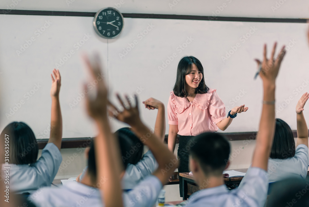 An smiling Asian female high school teacher teaches the white uniform ...