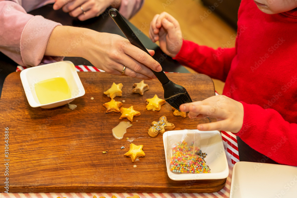 Son and mom decorating home baked biscuits. Involving children into ...