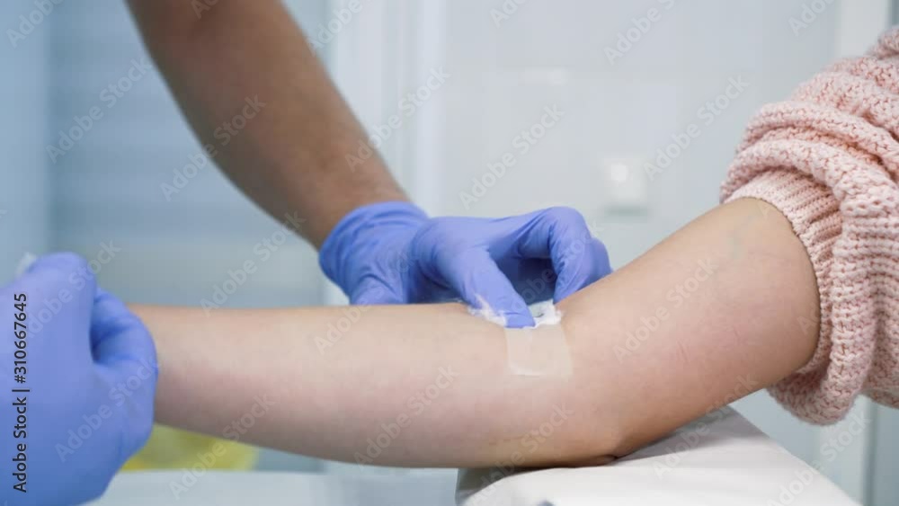 Vidéo Stock Nurse puts a piece of cotton wool on hand after finishing ...