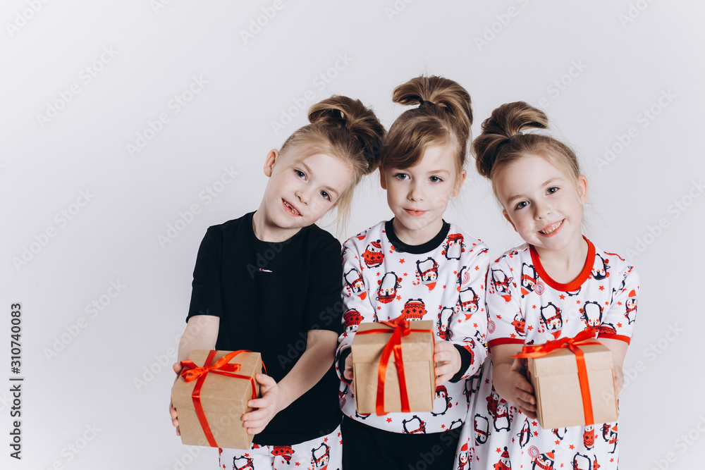 Happy cute adorable blondie triplets girls posing in studio together ...