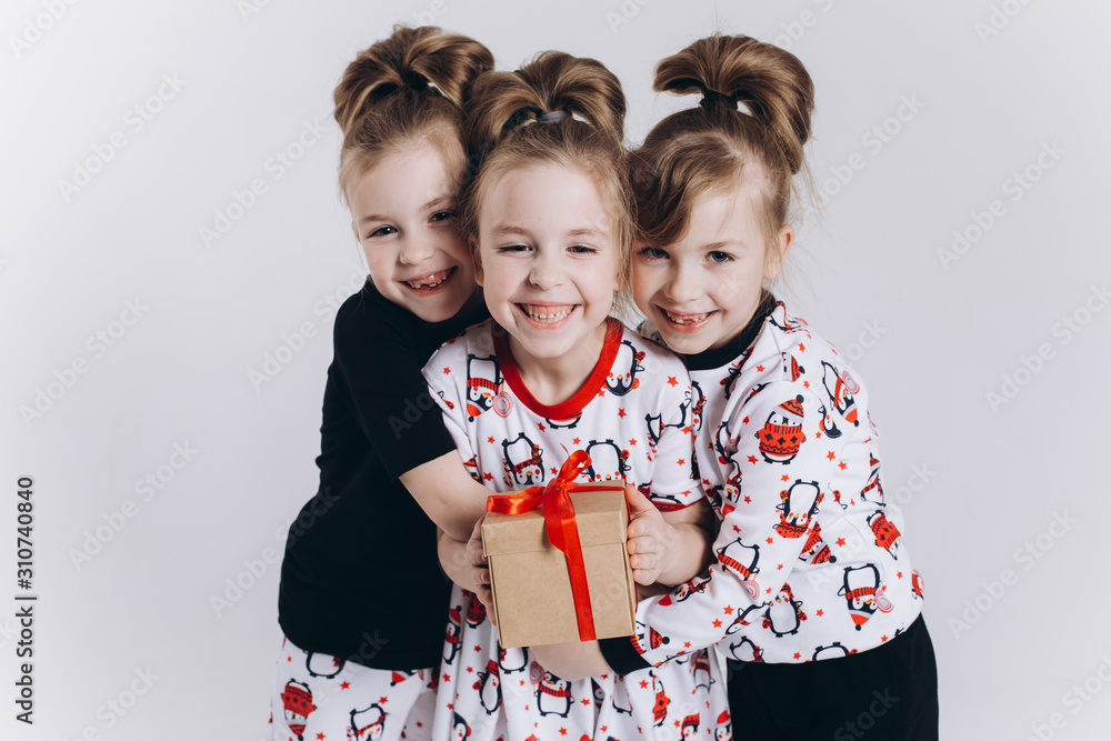 Happy cute adorable blondie triplets girls posing in studio together ...