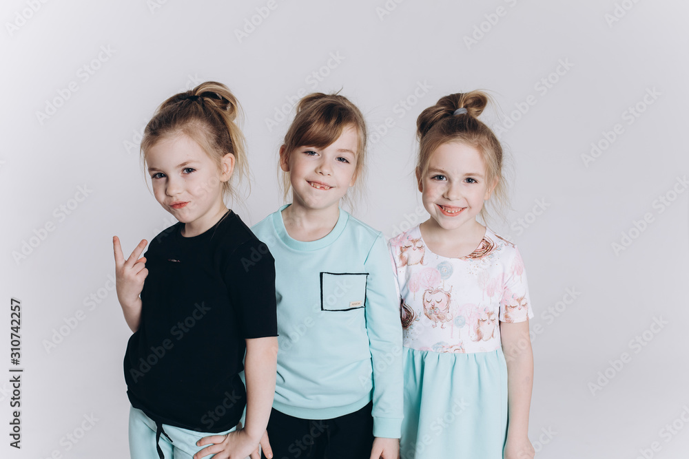 Happy cute adorable blondie triplets girls posing in studio together on ...