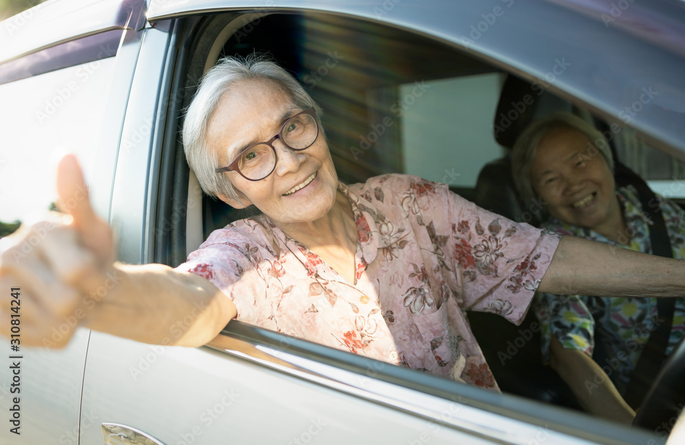 Happy smiling asian senior female driver in her car,enjoy traveling ...