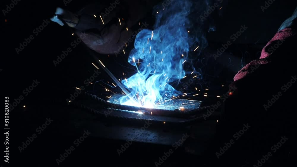 Welder working with welding machine. Bright flashes and smoke.. Welding ...