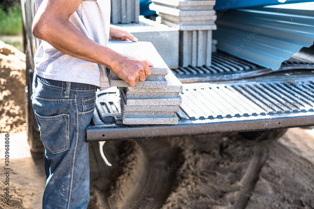 Worker moving heavy building materials from trunk car pickup ...