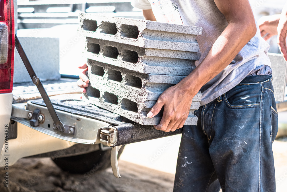 Worker moving heavy building materials from trunk car pickup ...