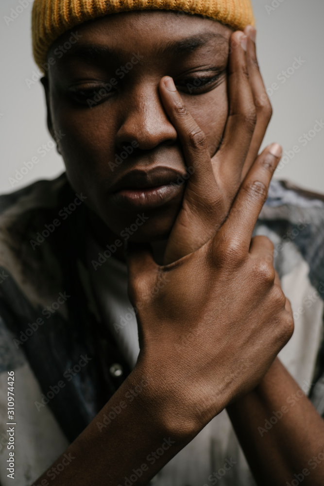 Close up of young man in knit hat resting face on hand Stock Photo ...