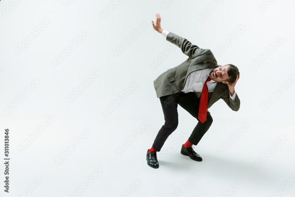 Young caucasian man moving flexible on white studio background. Male ...