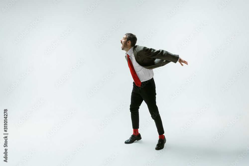 Young caucasian man moving flexible on white studio background. Male ...