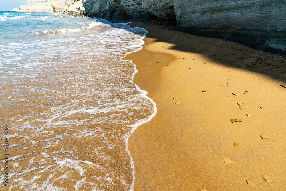 Tiny sandy beach with shallow water at the bottom of cliff. Beautiful ...
