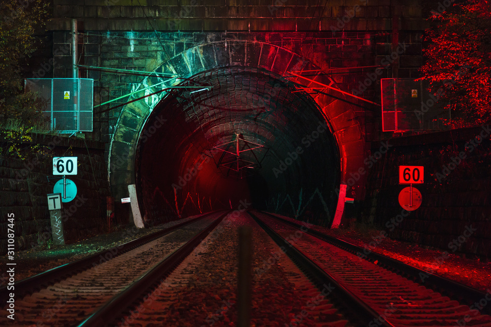 Railway tunnel lighted by signals in the night. Doubletrack railway ...