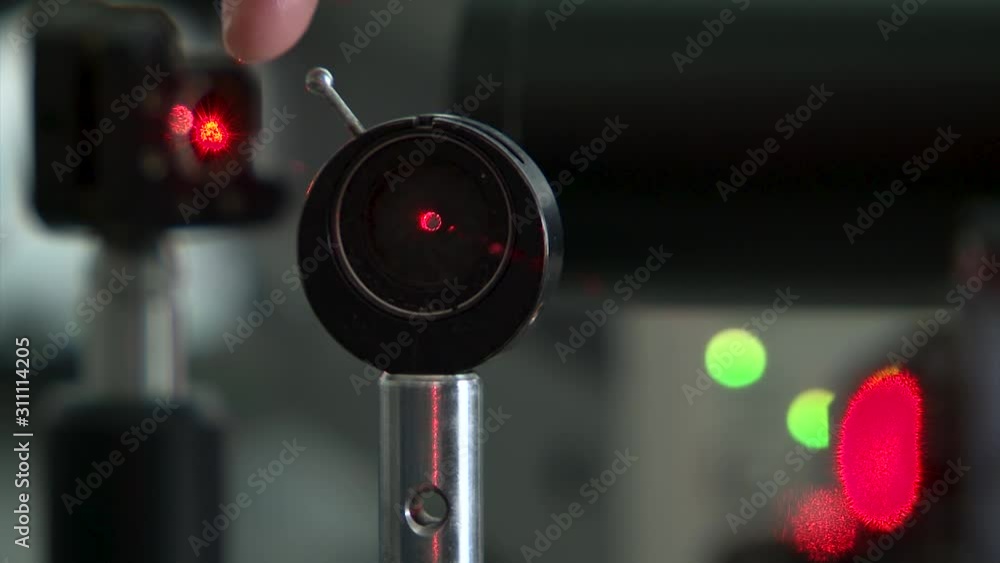 red laser beam in photonic lab. setup of laser in laboratory. hand ...