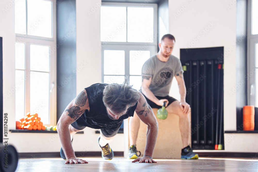 Two friends of men athletes doing strength training and interval ...