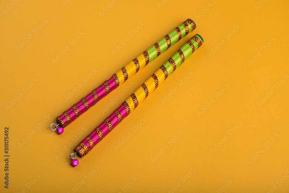 Dandiya sticks on a yellow background. Raas Garba or Dandiya Raas is ...