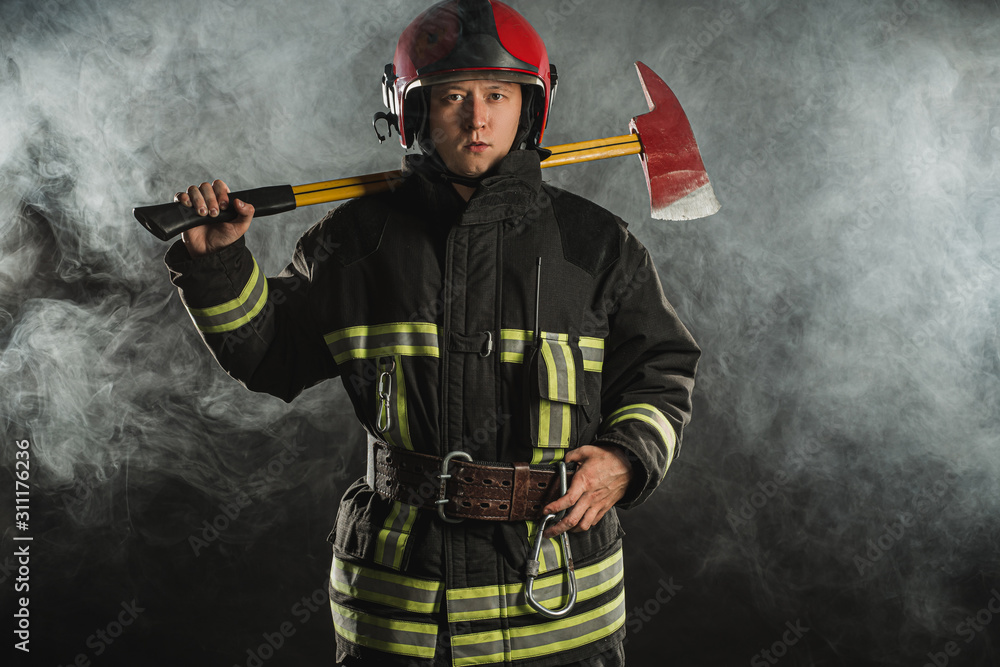 portrait of confident handsome fireman in helmet and uniform, serious ...