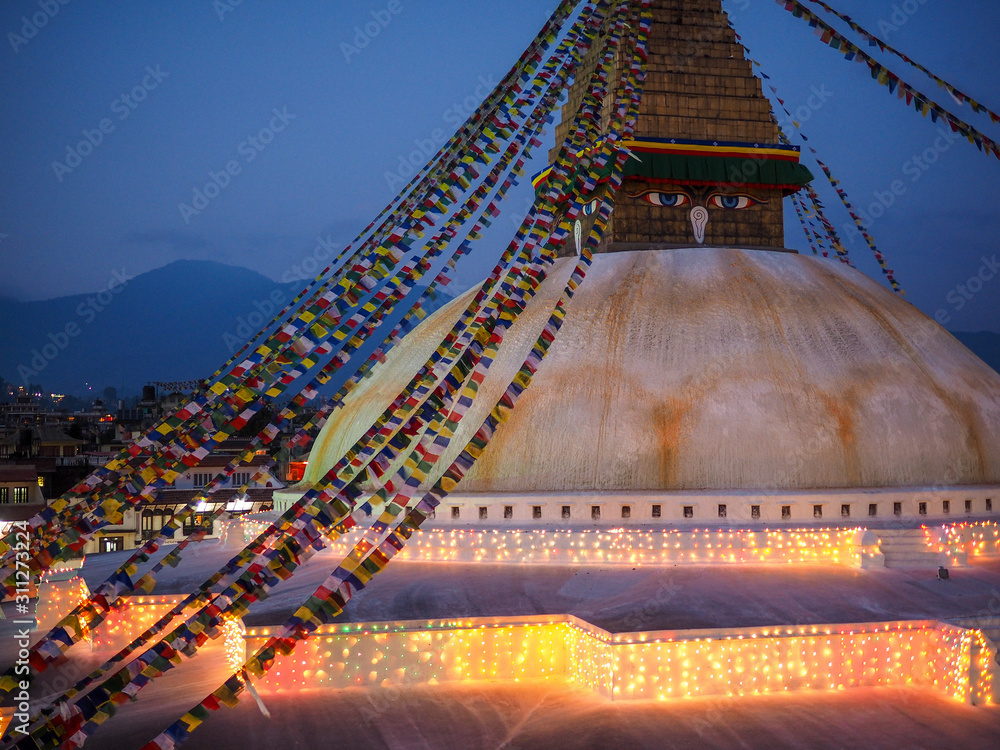 Buddhist shrine Boudhanath Stupa with pray flags over sunset sky. Nepal ...