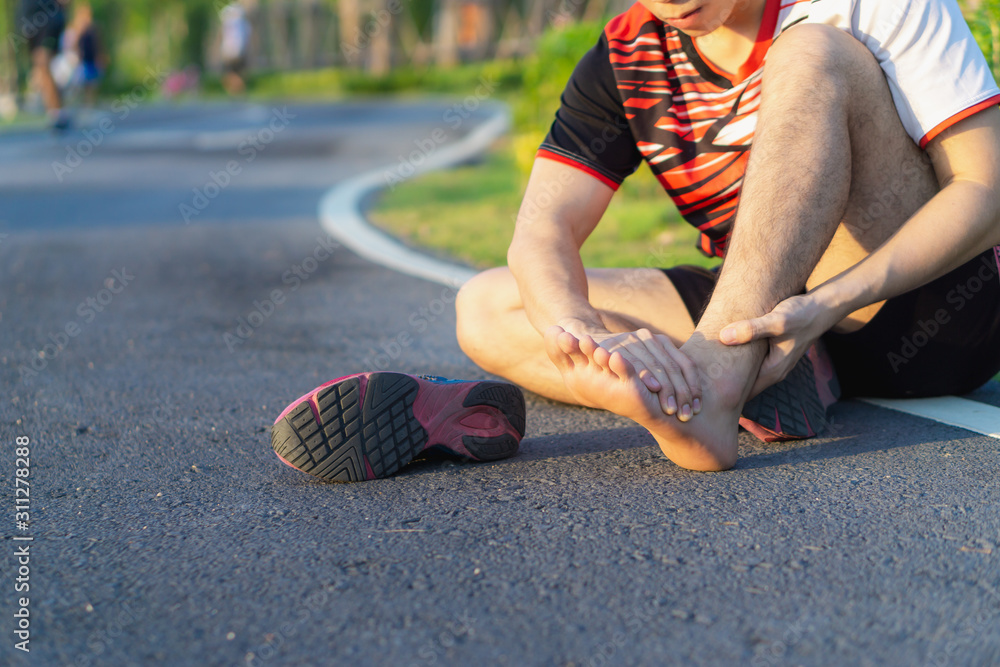 Ankle sprained. Young man suffering from an ankle injury while running ...