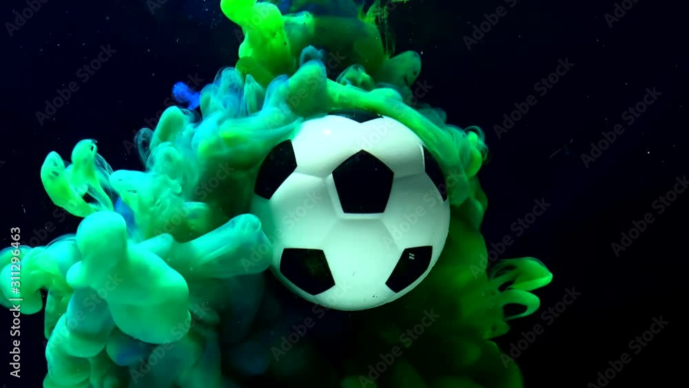 Soccer ball on an amazing background. Green and blue ink in water on a ...