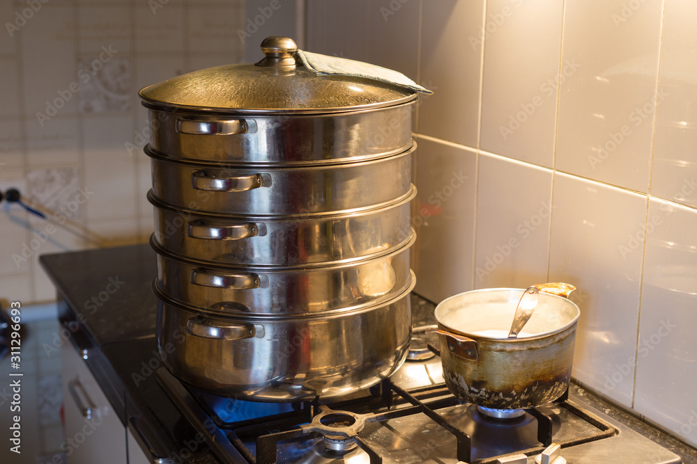 Juicy korean manti on a gas stove in a double boiler. Cooking delicious ...