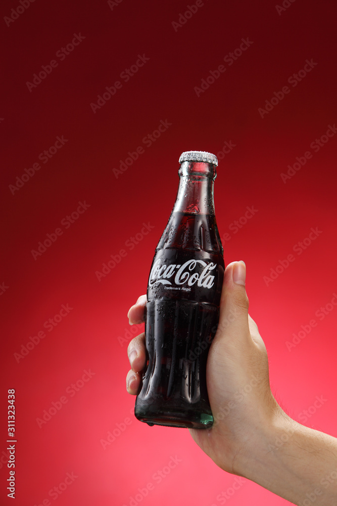 hand holding bottle of classic coca cola on the red background Stock ...