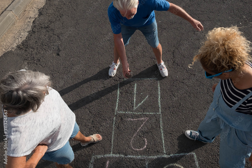 group of three people playing together in the street on the asphalt at ...