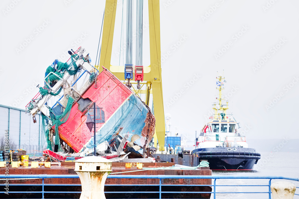 Capsized ship vessel and rescue lift crane at port dock for repair of ...