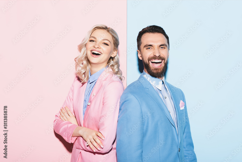 attractive woman and handsome man smiling at camera on pink and blue ...